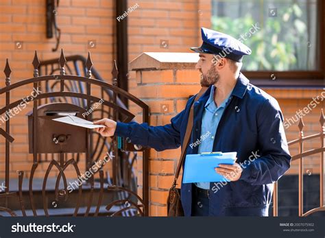 Handsome babe Postman Putting Letter Mail库存照片 Shutterstock