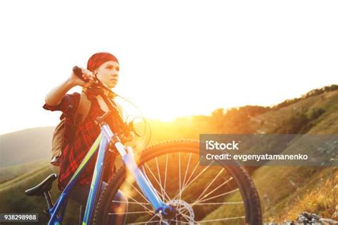 여름에 야외에서 하이킹 하는 동안 일몰에 산 꼭대기에서 자전거를 타고 여자 관광 건강한 생활방식에 대한 스톡 사진 및 기타