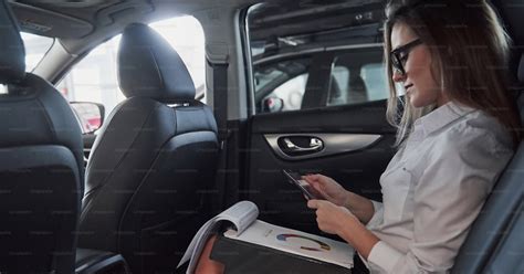 메모장의 문서 똑똑한 사업가는 검은 색 인테리어의 고급 자동차의 뒷좌석에 앉아 있습니다 사진 Unsplash의 수송 이미지