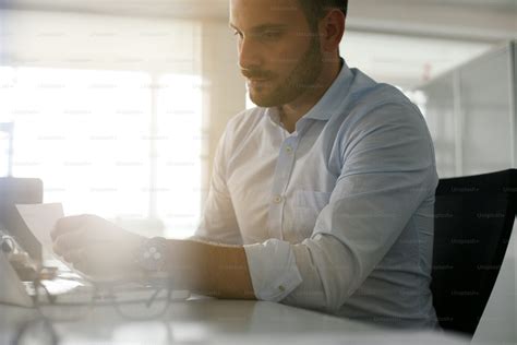 문서를 들고 노트북에서 전자 메일을 확인하는 사업가 사무실에 있는 사업가 사진 Unsplash의 세르비아 이미지