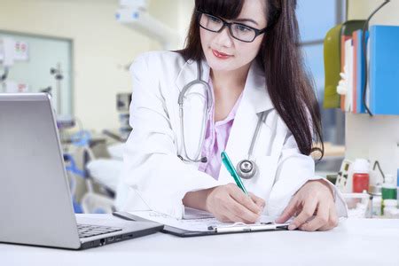 Attractive Female Doctor Is Writing Medical Report At The Clinic Stock Image Everypixel