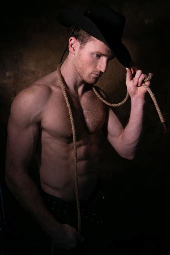 정의된 Pecs와 식스팩 복근 로프를 들고 있는 근육질의 팔을 보여주는 모자를 쓰고 있는 잘생긴 카우보이 가수에 대한 스톡 사진 및 기타 이미지 Istock