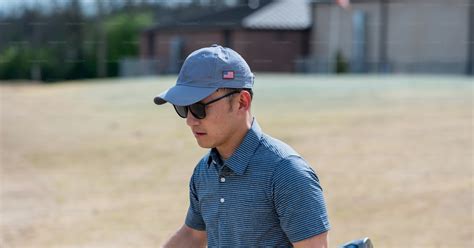 파란색 셔츠와 모자를 쓴 남자가 골프 클럽을 들고 있다 사진 Unsplash의 골프 이미지