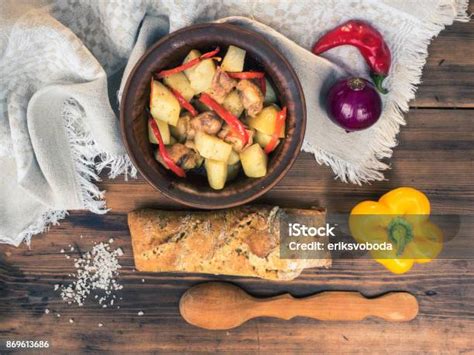 농촌 아직도 인생입니다 감자 빵 소금 후추와 나무 테이블과 거친 옷감의 배경에 양파와 구운된 고기 나무 숟가락으로 점토 그릇에 감자를 구운 상위 뷰 0명에 대한 스톡 사진