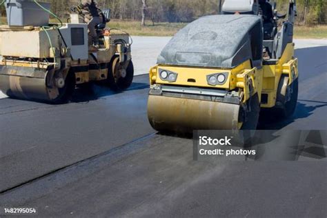 건설 현장에 새 아스팔트를 깔고 있는 진동 도로 롤러 압축기 공정 기계를 작동하는 작업자 아스팔트 포장 기계에 대한 스톡 사진 및 기타 이미지 아스팔트 포장 기계 증기