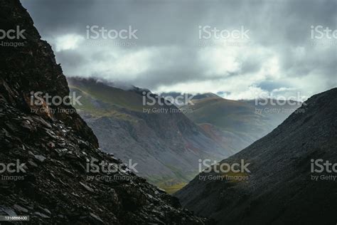 흐린 날씨에 녹색 잡동리 산 계곡에 경년의 가장자리에서 어두운 대기 전망 위험한 산과 회색 하늘 아래 의 경애와 고원 풍경 비오는 날씨에 산 패스 0명에 대한 스톡 사진 및