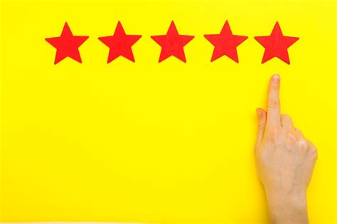 5 별 은 등급 고객 경험 개념을 증가 서비스 등급을 높이기 위해 5성 기호를 넣는 클라이언트의 손 노란색 배경에 5 개의 빨간 별 우수한 등급 만족도 개념 1위에 대한