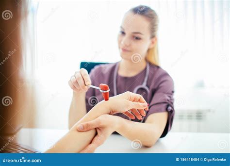 Neurological Examination The Neurologist Testing Reflexes On A Female