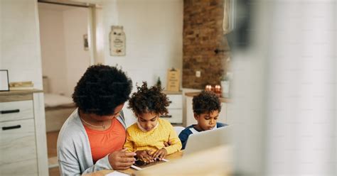 아프리카계 미국인 어머니는 집에서 일하는 동안 딸과 이야기합니다 작은 소년이 그들 옆에 앉아 있습니다 공간을 복사합니다 사진 Unsplash의 전업주부 이미지