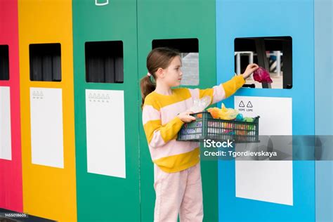 다른 비닐 봉지와 상자를 들고 소녀 아이들이 재활용 쓰레기통에 비닐 봉지 쓰레기를 던지고 있다 폐기물 제로 재활용 환경 문제 0