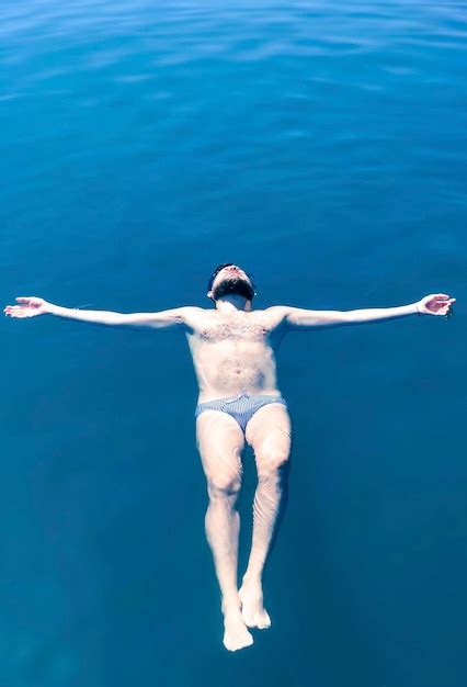 Premium Photo Full Length Of Man Floating On Water In Sea