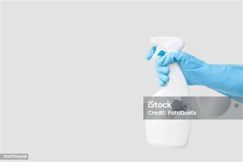 청소기의 파란색 고무 보호 장갑 흰색 화학 스프레이 병을 들고 있는 손 텍스트 또는 회색 바탕에 로고에 대 한 빈 장소 이른 봄 또는 일반 정리입니다 상업적인 청소