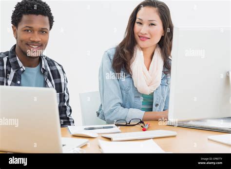 Casual Couple Using Computers In Office Stock Photo Alamy