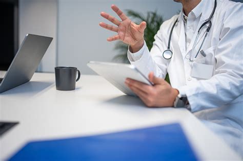 흰 코트를 입은 중반 성인 아시아 의사가 디지털 태블릿으로 사무실 회의에서 논의 40 44세에 대한 스톡 사진 및 기타 이미지 40 44세 건강관리와 의술 남성