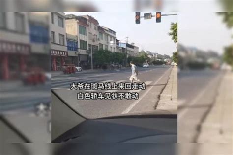 大爷在斑马线上行走白色轿车见状不敢动弹网友礼让行人是为了保护车主 轿车 斑马线 行人