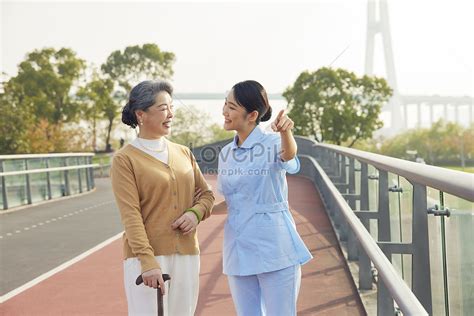 야외에서 노인과 함께 걷는 젊은 여성 간병인 사진 무료 다운로드 Lovepik
