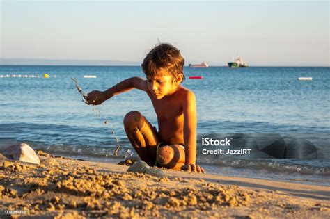 바닷가 모래에서 놀고 있는 아름다운 소년 저녁 햇살을 받으며 모래와 바다를 배경으로 다양한 창작 게임을 합니다 4 5세에 대한