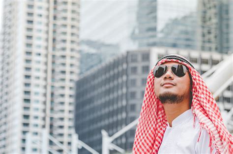 스마트 태블릿을 들고 사용 하 여 잘 생긴 현대 아라비아 남자 도시에서 걷는 동안 스마트 폰 통화를 사용하는 아랍 남자 비즈니스 성공 개념 가정 생활에 대한 스톡 사진 및