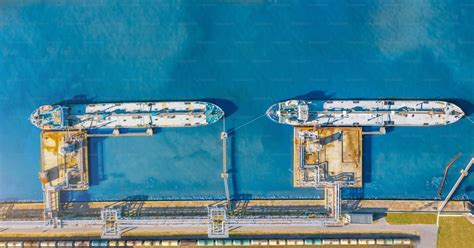 석유 터미널의 공중 평면도 넓은 파노라마와 부두에 액체 연료를 싣고 계류된 유조선 2척 적재 및 하역을 위한 철도 탱크 차량 사진 Unsplash의 산업 이미지