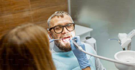 치과 진료소에서 여성 치과 의사와 치아 검사 중 환자로 잘 생긴 남자 사진 Unsplash의 치과의사 이미지