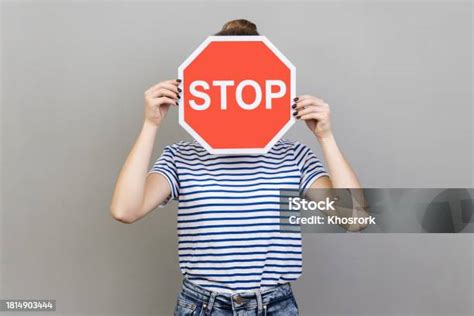 정지 표지판 뒤에 얼굴을 숨기고 가정 폭력에 대해 이야기하는 것을 두려워하고 피해자를 무서워합니다 25 29세에 대한 스톡 사진 및 기타 이미지 Istock