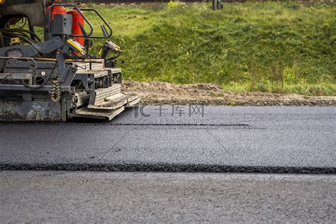 工业沥青摊铺机在道路施工现场铺设新鲜沥青高清摄影大图 千库网