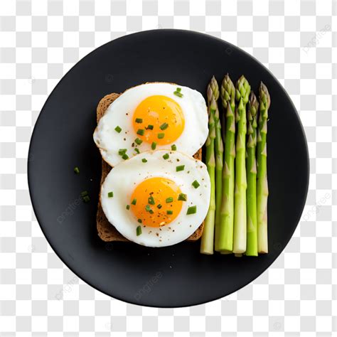 검정 접시에 계란 두 개에 노란색 노른자와 잘게 잘린 녹색 허브를 얹고 구운 갈색 빵 조각을 뿌립니다 토스트에 아스파라거스를 곁들인 맛있는 수란 계란 토스트 맛있는