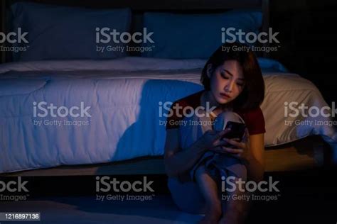 우울한 젊은 아름다운 아시아 여성은 스마트 폰을보고 침실 바닥에 혼자 앉아 스트레스 불면증 슬픈 여자는 삶의 문제를 가지고 정신 건강 건강 관리 및 사회 문제 개념 여자에