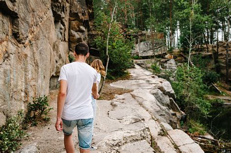 다리 젊은 부부는 호수 근처 돌에가 고 전체 길이 바위의 배경에 뒤에서 남자와 여자의 보기 오래 된 산업 화강암 채 석 장의 풍경입니다 닫습니다 손을 잡고 있는 사람들 2