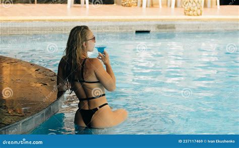 The Pretty Woman Drinking Blue Cocktail Alcohol Liquor And Sit At The