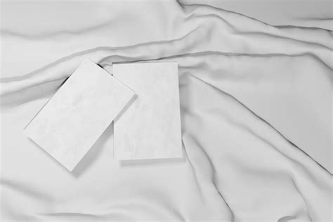 광택 있는 실크 천 D 렌더링에 모형 복사 공간이 있는 빈 종이 시트 카드 2개 프리미엄 사진