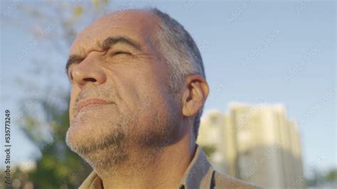 Old Retired Man Sunbathing Man Sitting Outdoors In The Park Is Sitting