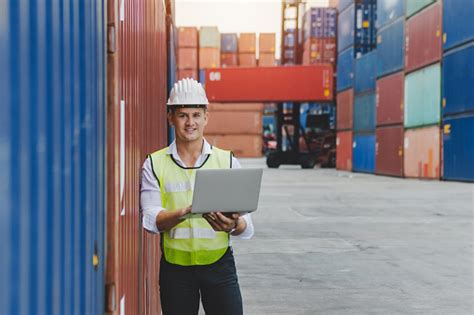 컨테이너 화물 항구 산업 물류 수입 및 수출 개념에서 백그라운드에서화물 컨테이너와 디지털 노트북 컴퓨터에서 작업 하는 백인 백인 사업가 또는 엔지니어 제어 노동자 경영자에