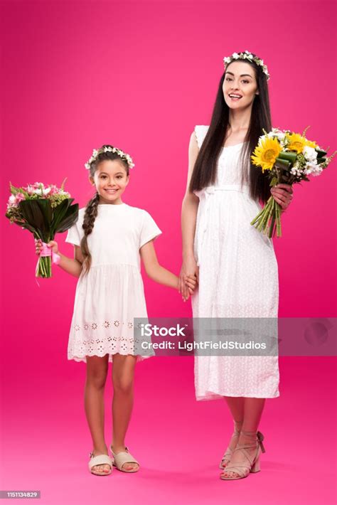 흰색 드레스와 꽃 화 환 부케를 들고 분홍색에 카메라에 웃는 아름 다운 행복 한 어머니와 딸의 전체 길이 보기 2명에 대한 스톡 사진 및 기타 이미지 Istock