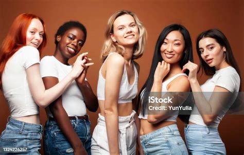 젊은 예쁜 백인 아프로 아시아 스칸디나비아 여성은 갈색 배경에 함께 명랑 포즈 라이프 스타일 다양한 국적 사람들 개념 갈색에