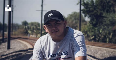 흰색 크루넥 티셔츠와 파란색 데님 청바지를 입은 남자가 기차 레일에 앉아 있다 사진 Unsplash의 무료 회색 이미지