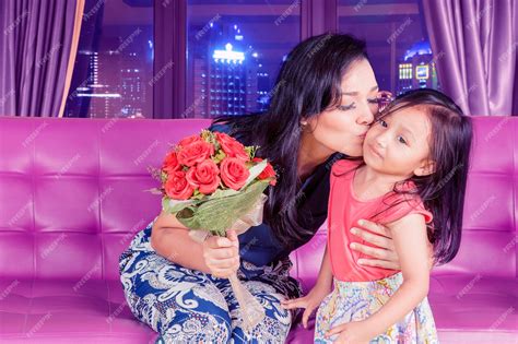 Premium Photo Woman Kiss Daughter While Receiving Flowers