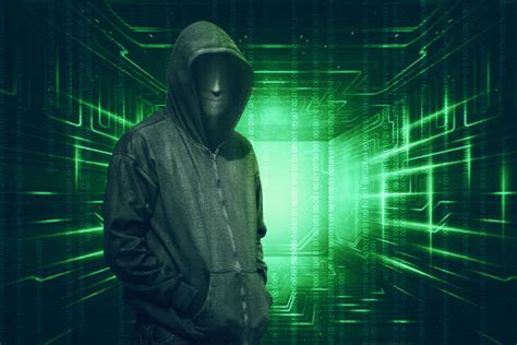 100 Hooded Computer Hacker In The Shadow With Program Codes Stock