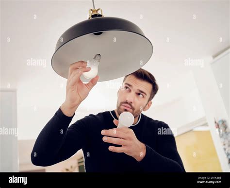 Man Changing Old Lightbulb For A LED Energy Saving Lightbulb Stock Photo Alamy
