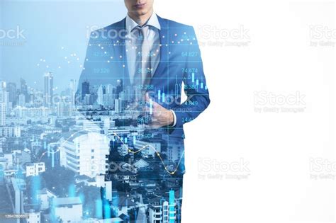 매력적인 젊은 유럽 사업가는 인덱스 촛대 외환 차트 및 모의 장소와 추상적 인 푸른 도시 배경에 서있다 성공 핀테크 변형 및 무역 개념 이중 노출 그래프에 대한 스톡 사진