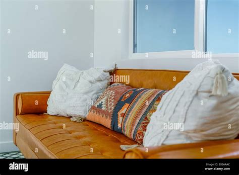 Brown Leather Couch And Decorative Southwestern Pillows In A Modern