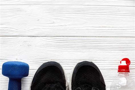 피트 니스 아령 운동 화 및 백색 배경에 나무 평면 물 병 개념이 하다 텍스트에 대 한 공간 선수의 설정 개념 건강 한 라이프 스타일 스포츠 및 다이어트입니다 스포츠 장비