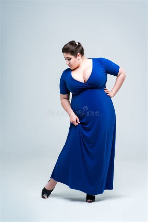 Plus Size Fashion Model In Blue Dress With A Deep Neckline Outdoors