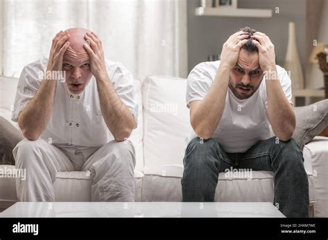 Senior Father And Adult Son Holding Their Head Terrified By Bad News Or