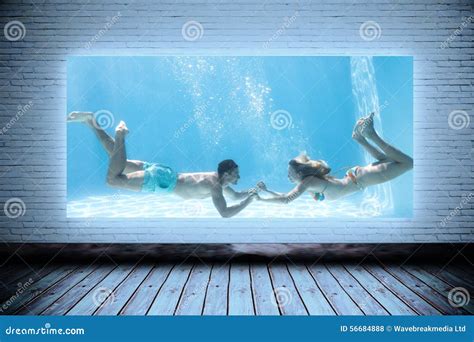 Composite Image Of Cute Couple Holding Hands Underwater In The Swimming