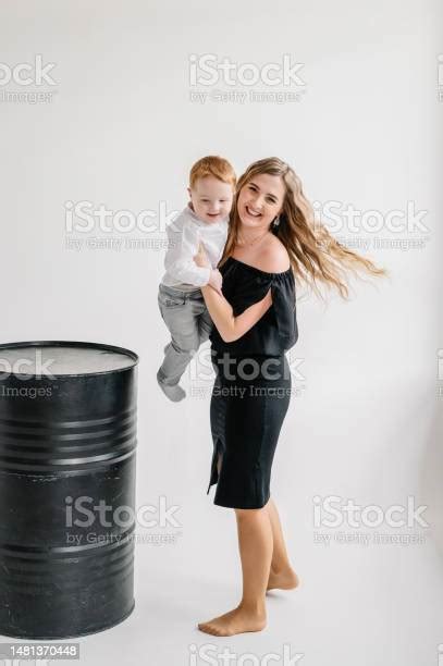 젊은 행복한 엄마는 스튜디오의 하얀 배경 벽에 고립된 어린 아들을 껴안는다 아이들을 껴안고 아이와 노는 재미있는 부모 엄마와 아들 근접 촬영 사진 가족 스튜디오 초상화 12