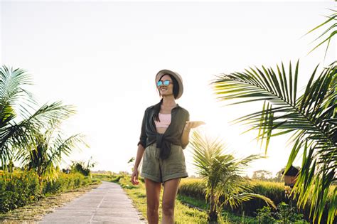 모바일 기술을 손에 들고 여름 동안 열대 시골을 탐험하는 쾌활한 여성 관광객 햇볕이 잘 드는 길을 산책하는 스마트폰 장치를 가진 즐거운 Caucaisan 힙스터 소녀 35