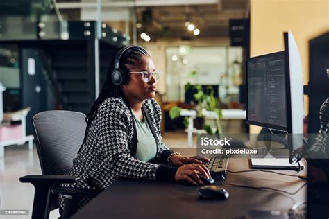 Computer Programmer Coding Artificial Intelligence In Modern Office Wearing Headphones Stock