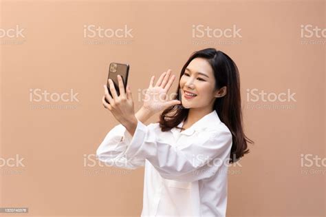 스마트 폰으로 얼굴 시간 비디오를 호출하는 아름다운 젊은 아시아 여성의 초상화 그녀는 회의 모임 응용 프로그램과 친척에게 셀카 또는 화상 통화를 스마트폰에 대한 스톡 사진