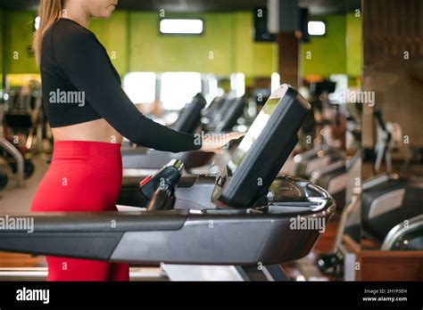 Woman Point To Button Of Speed Control Of Treadmill In Fitness Center Set Up Program Before